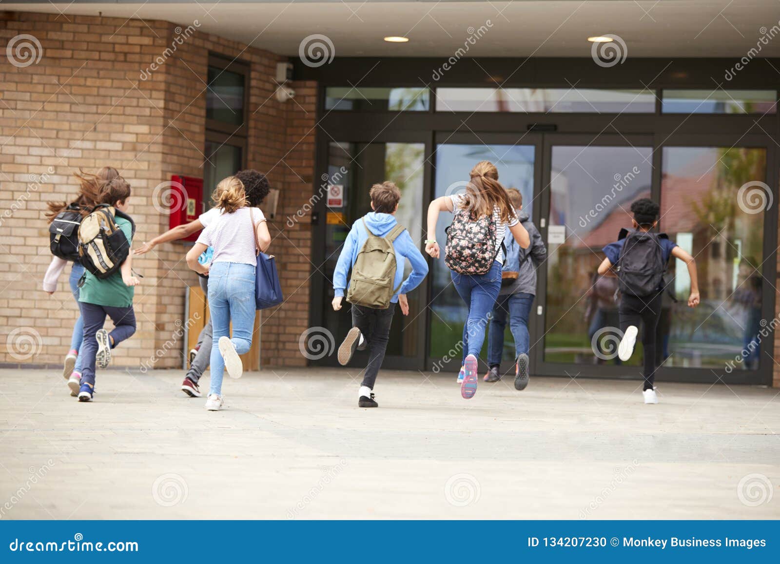 Group of High School Students Running into School Building at Beginning ...