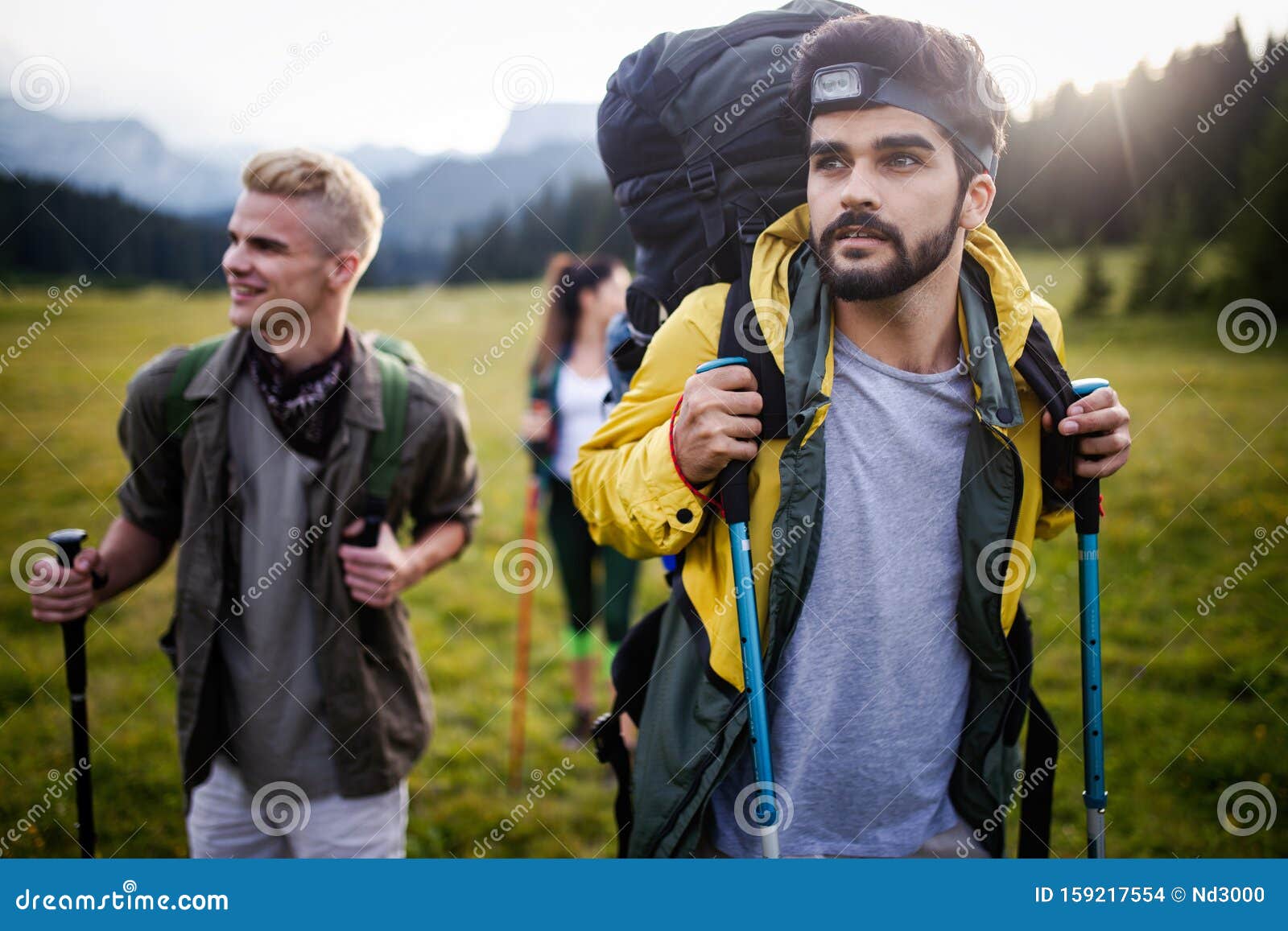 Group of Hikers with Backpacks and Sticks Walking on Mountain. Friends ...