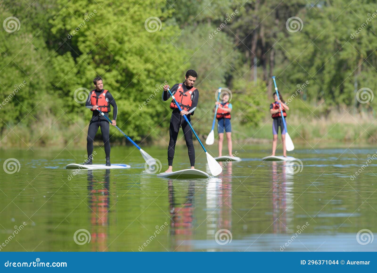 Group Holiday Maker Doing Stand Up Paddle Board Lesson Stock Photo ...