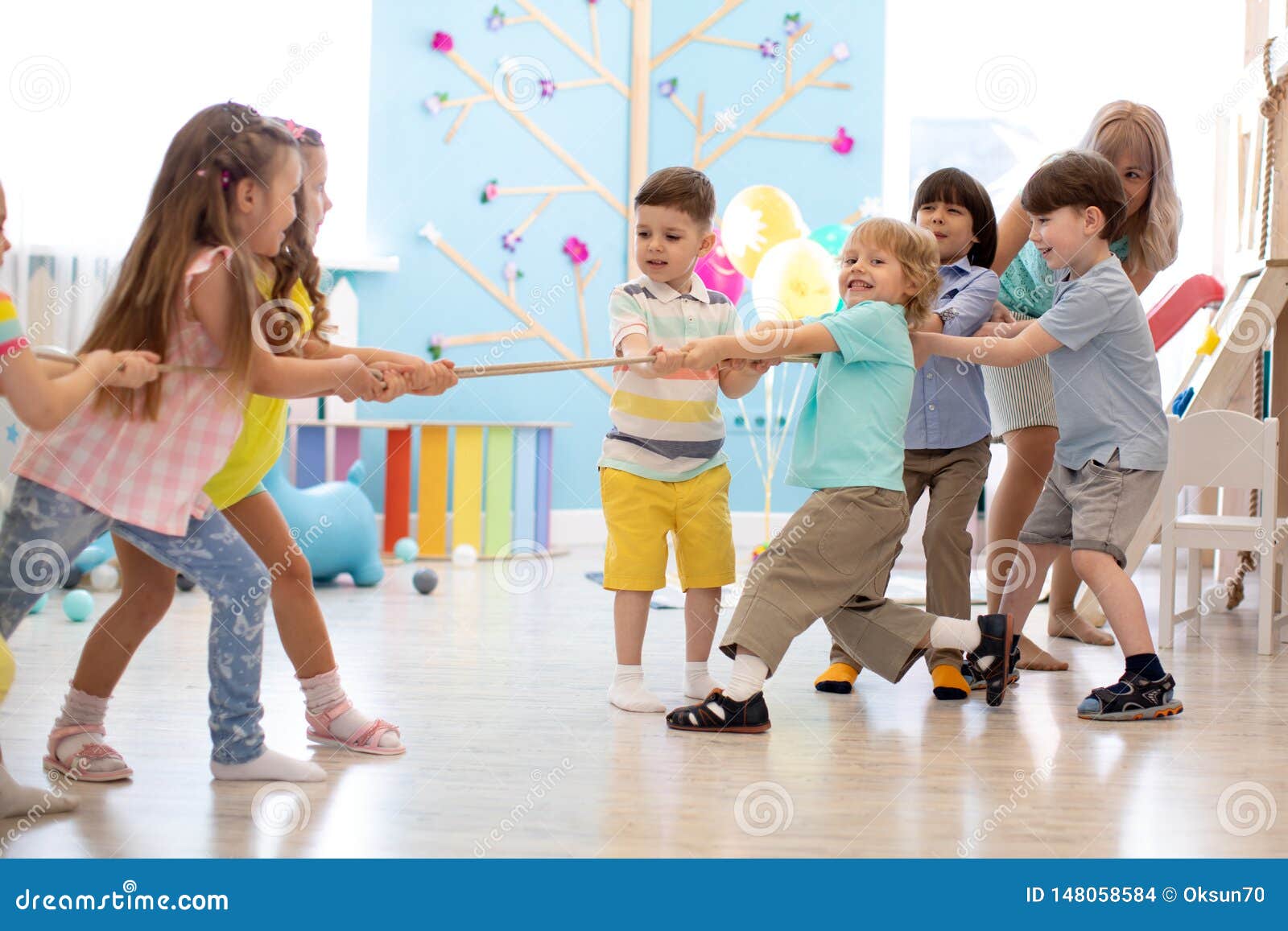 Group of Kids Play and Pull Rope Together in Daycare Stock Photo ...