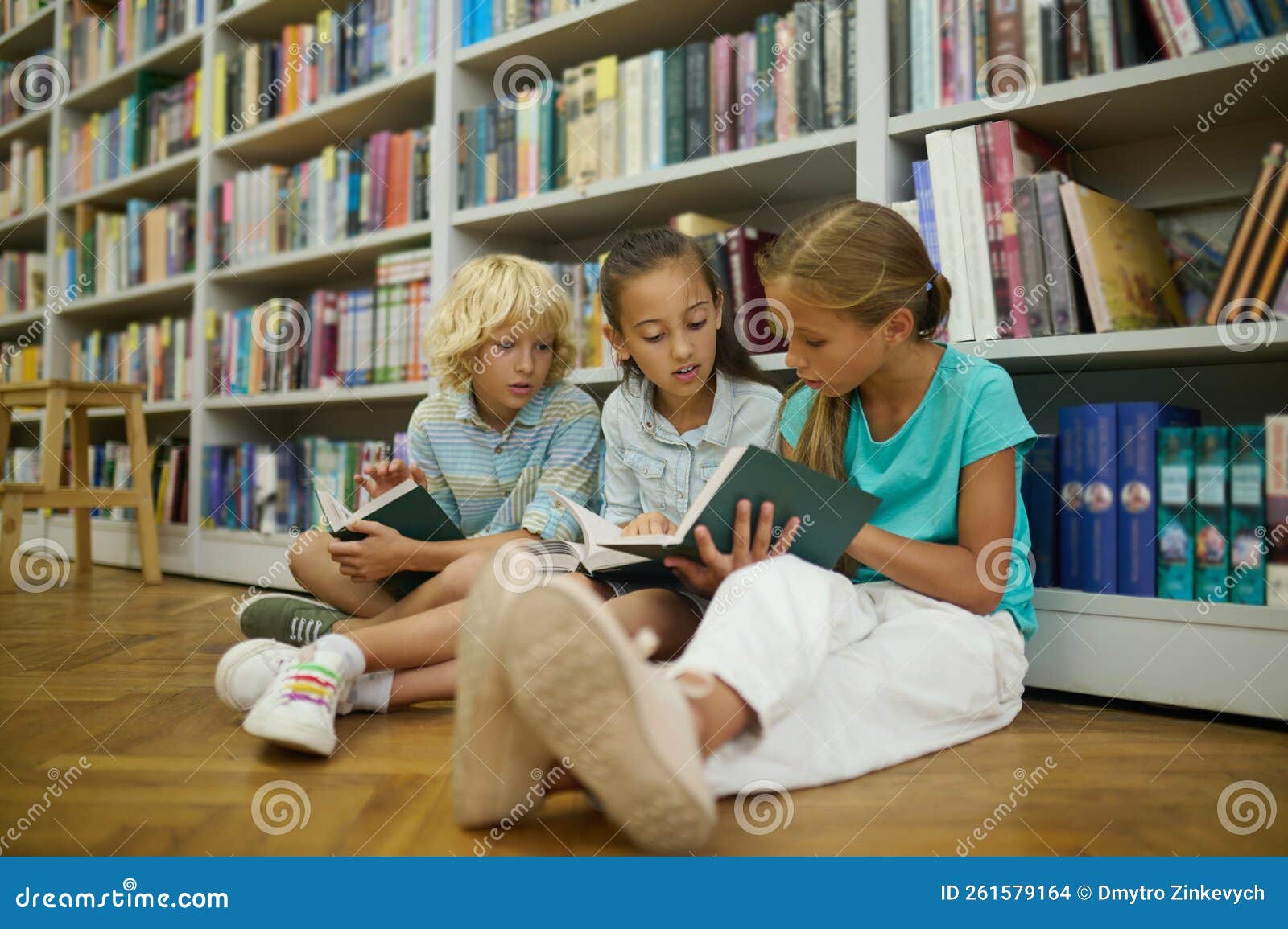 Group of Kids Reading while Sitting on the Floor in the Library Stock ...