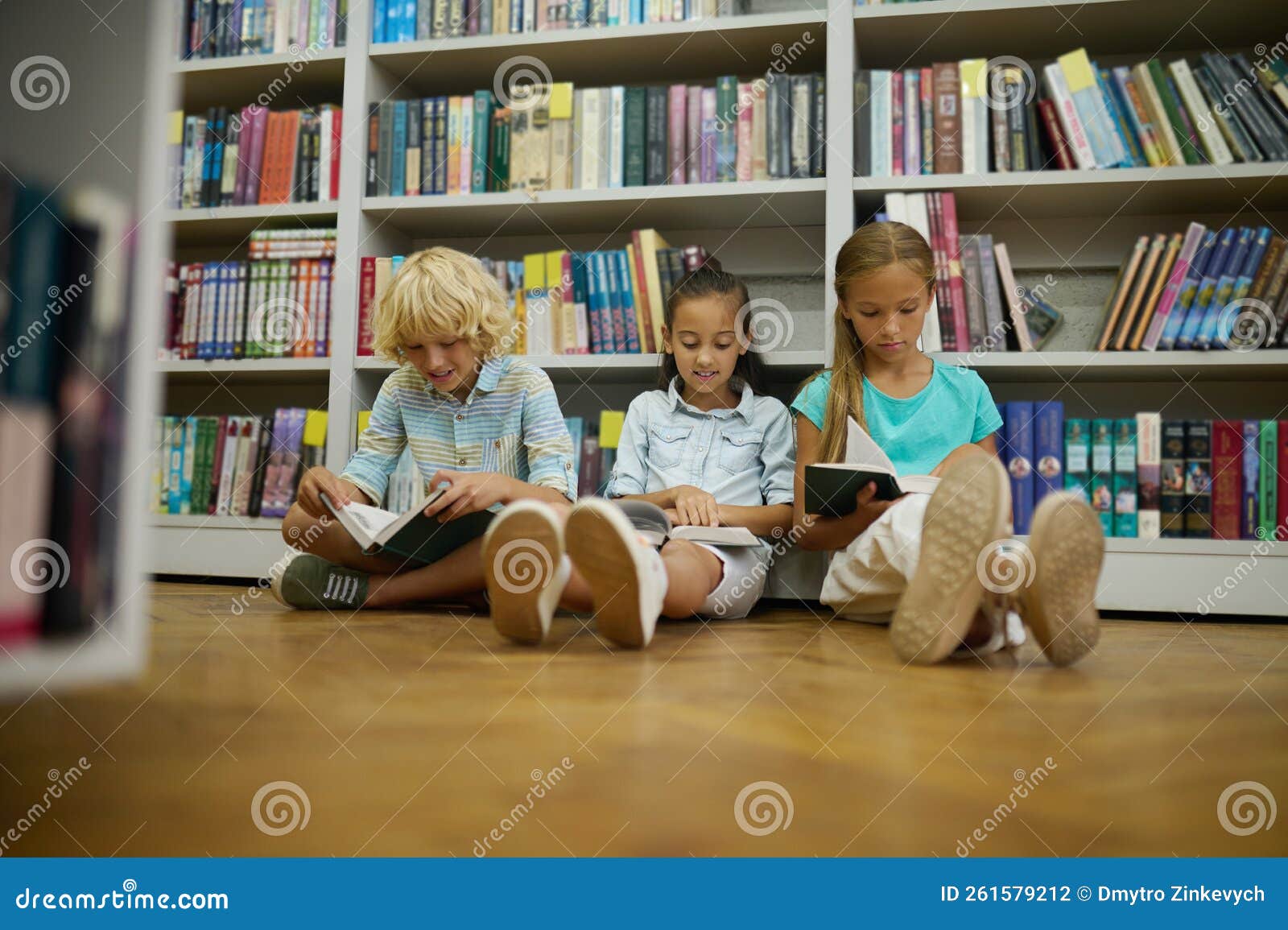 Group of Kids Reading while Sitting on the Floor in the Library Stock ...