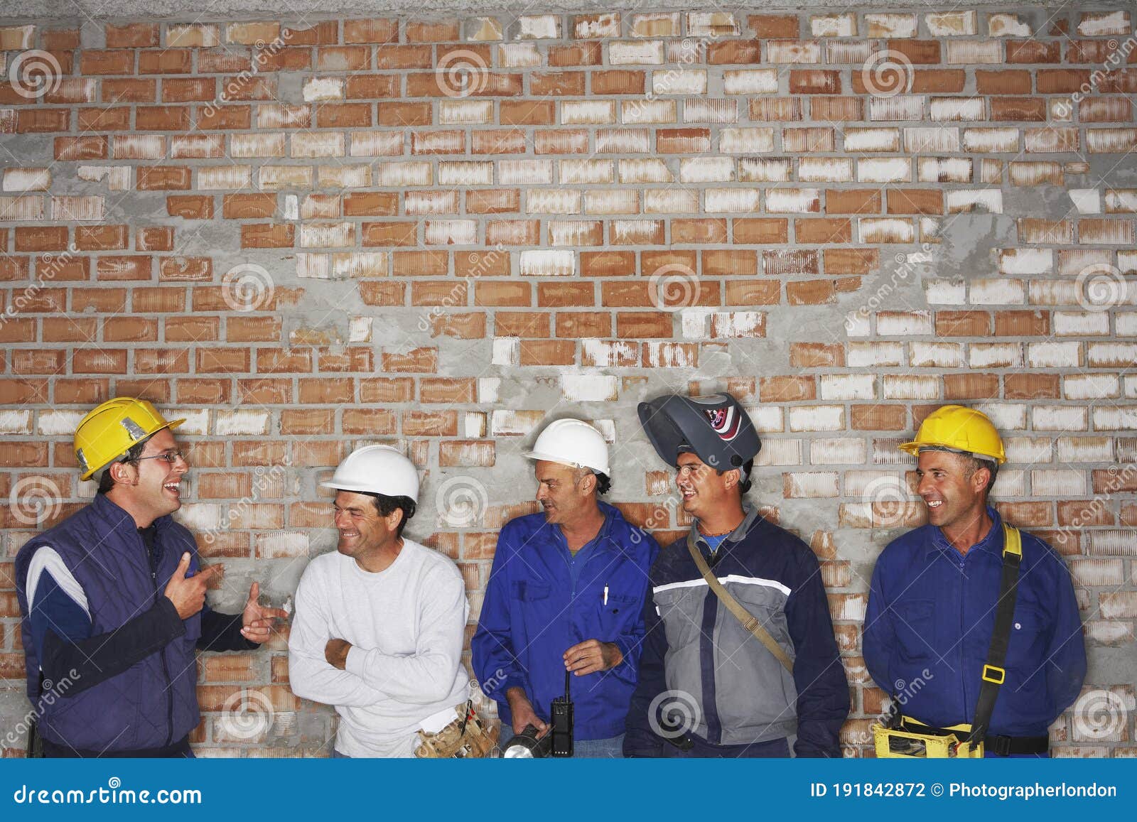 Group of Laughing Construction Workers by Brick Wall Stock Photo ...