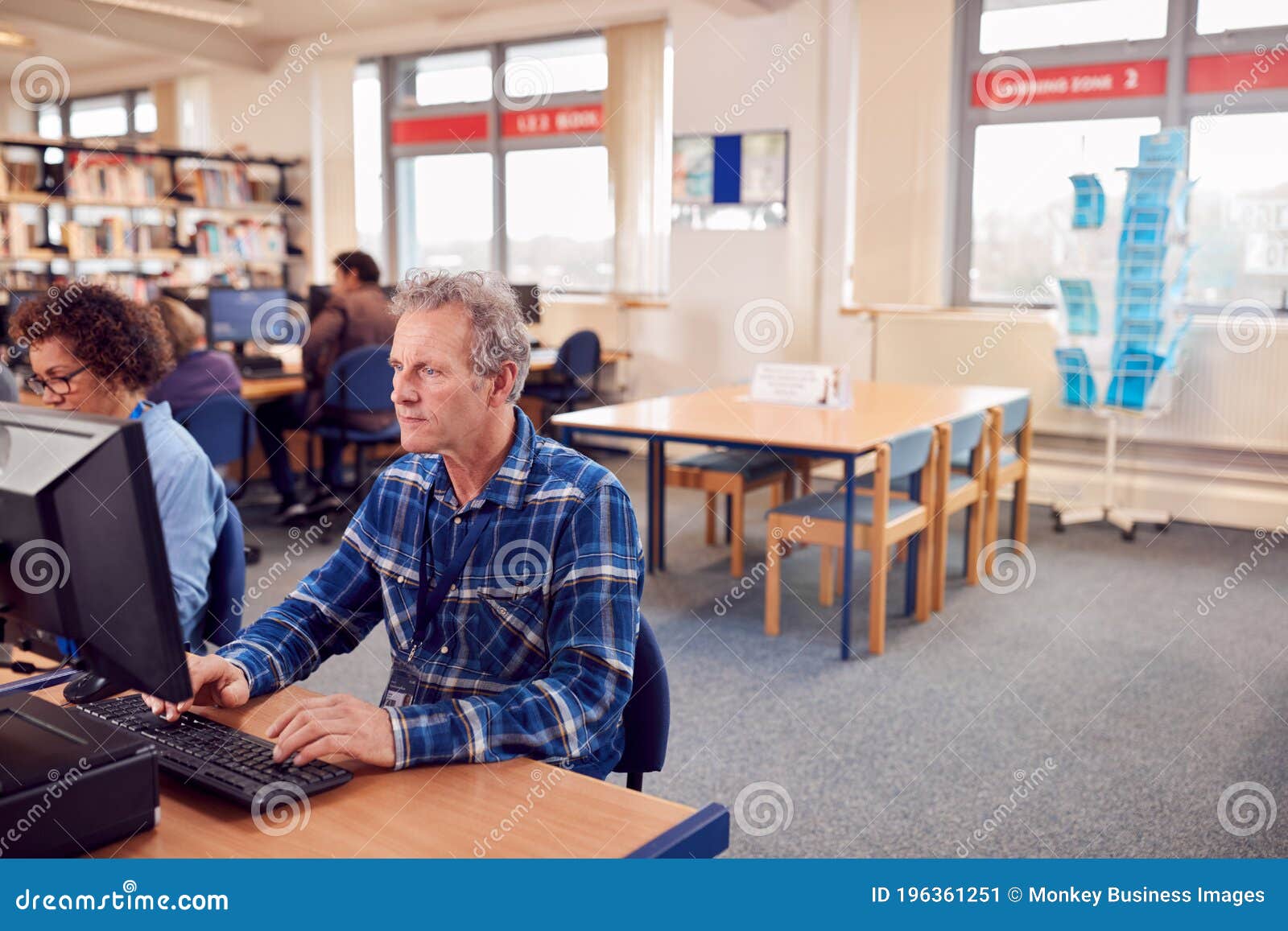 Group of Mature Adult Students in Class Working at Computers in College ...