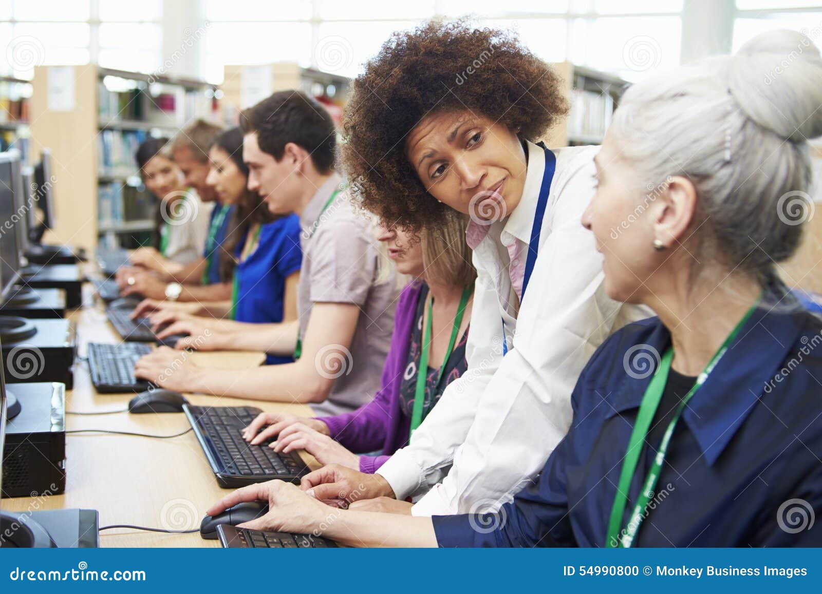 Group of Mature Students Working at Computers with Tutor Stock Photo ...