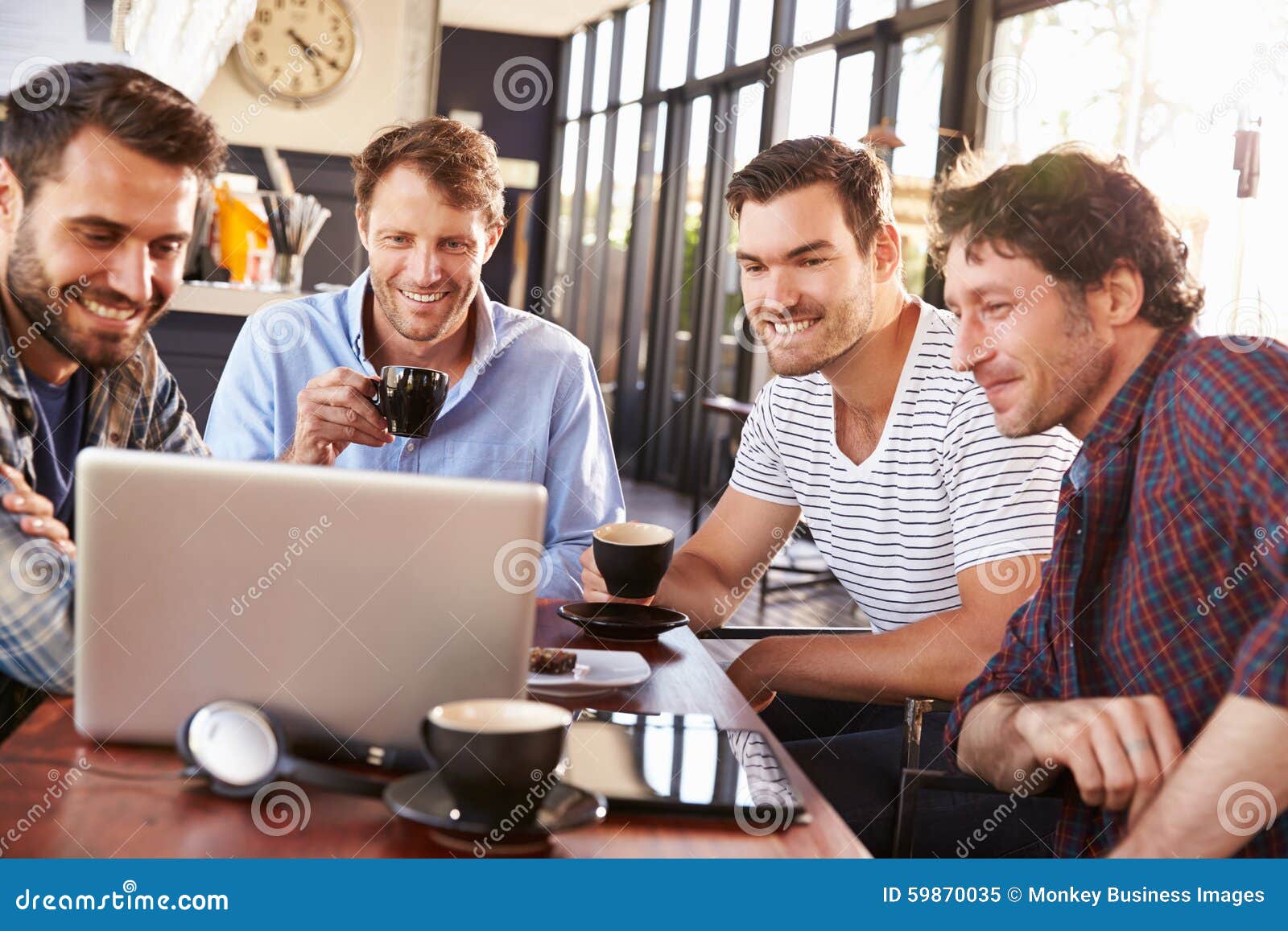Group of Men Looking at a Laptop Together at a Coffee Shop Stock Image ...