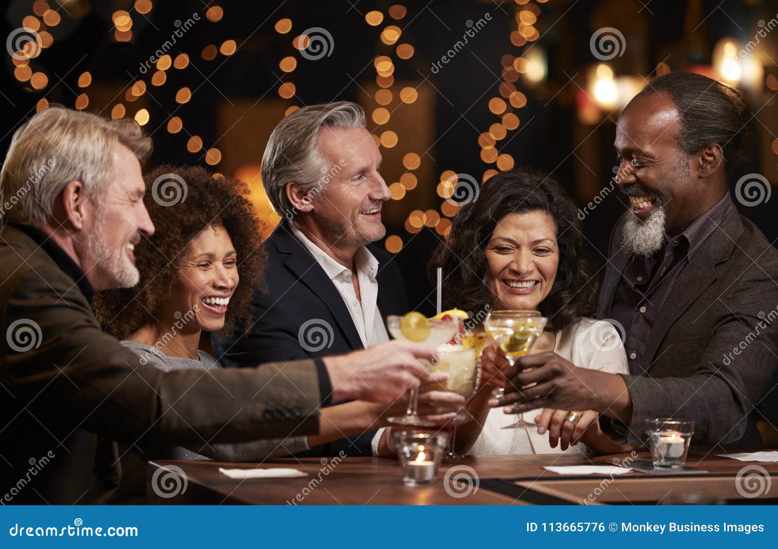 Group of Middle Aged Friends Celebrating in Bar Together Stock Photo ...