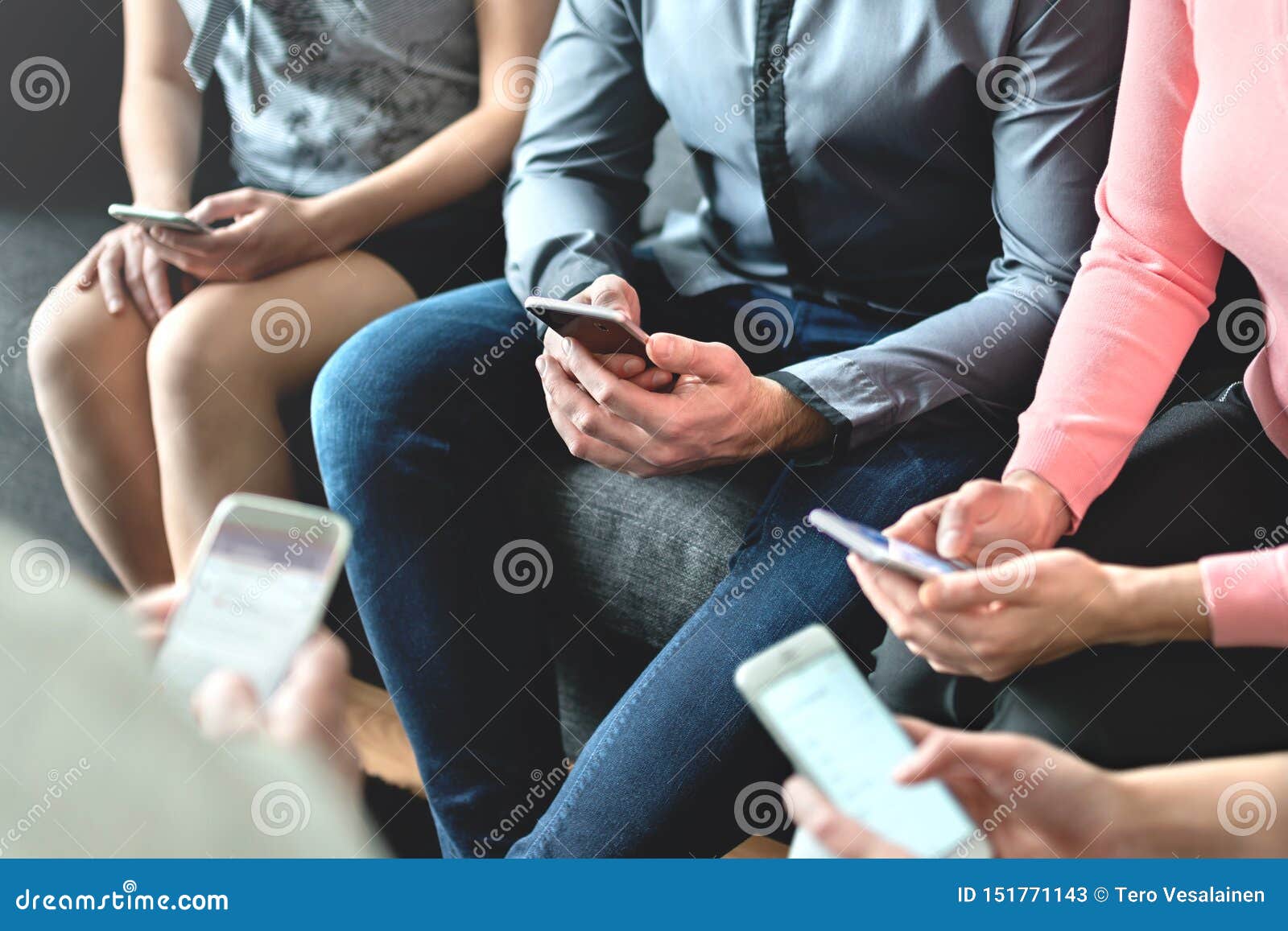 Group of Millennial Business People Using Mobile Phones and Sitting on ...