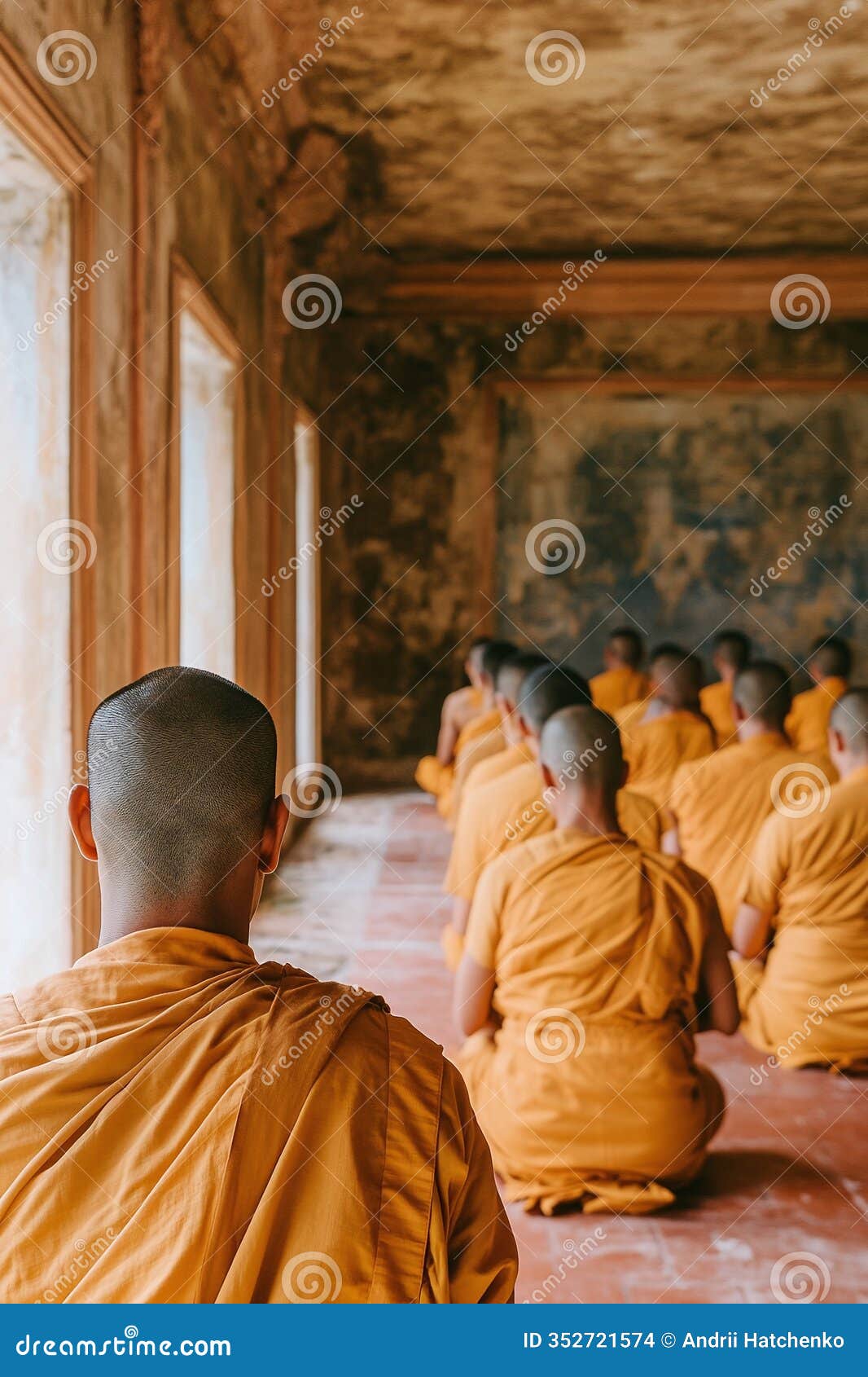 A Group of Monks in Saffron Robes Praying in a Line Inside an Ancient ...