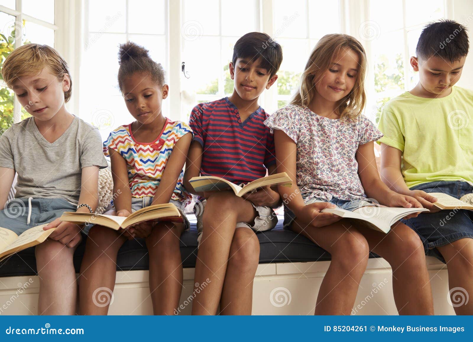 Group of Multi-Cultural Children Reading on Window Seat Stock Image ...