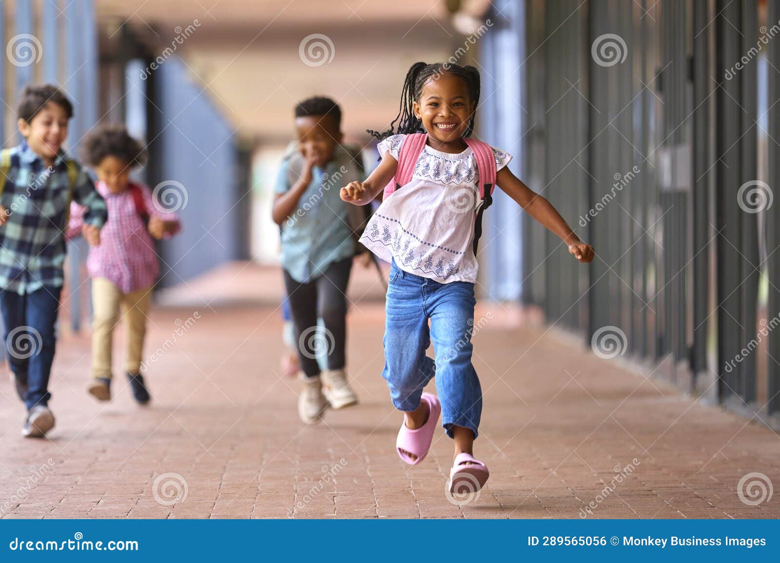 Group of Multi-Cultural Elementary School Pupils Running Along Walkway ...