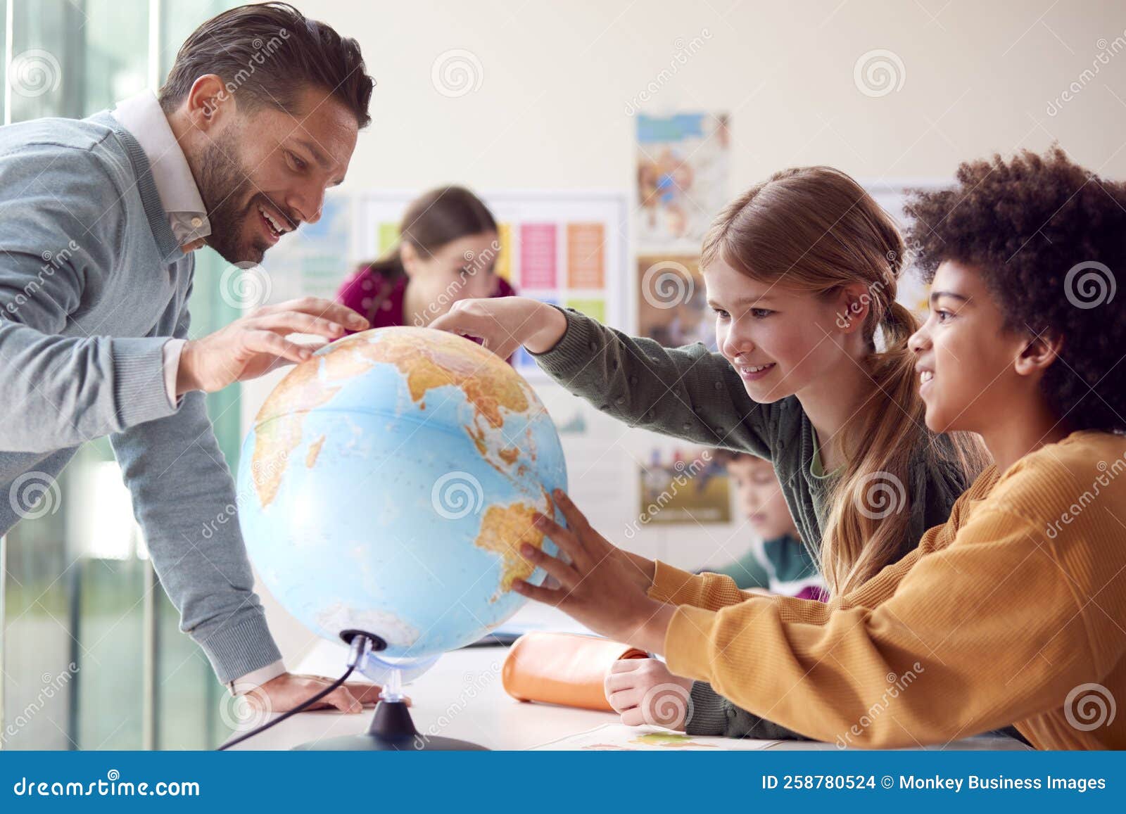 Group of Multi-Cultural Students with Teachers in Classroom Looking at ...