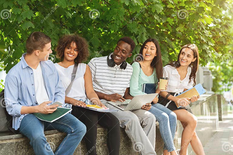 Group of Multicultural Students Sitting in the University Courtyard ...