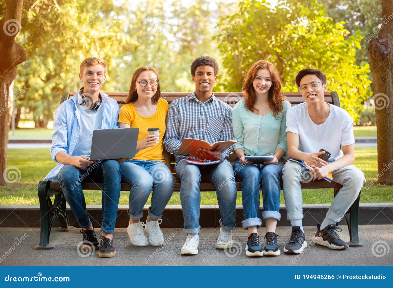 Group of Multiethnic Students Posing Sitting on Bench Learning Outside ...