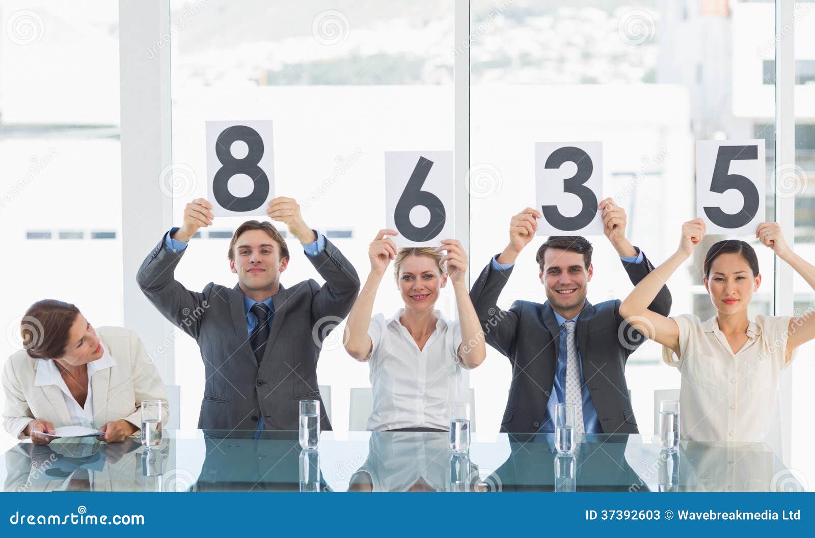 Panel Of Judges Holding Different Score Signs At Table On Brown ...