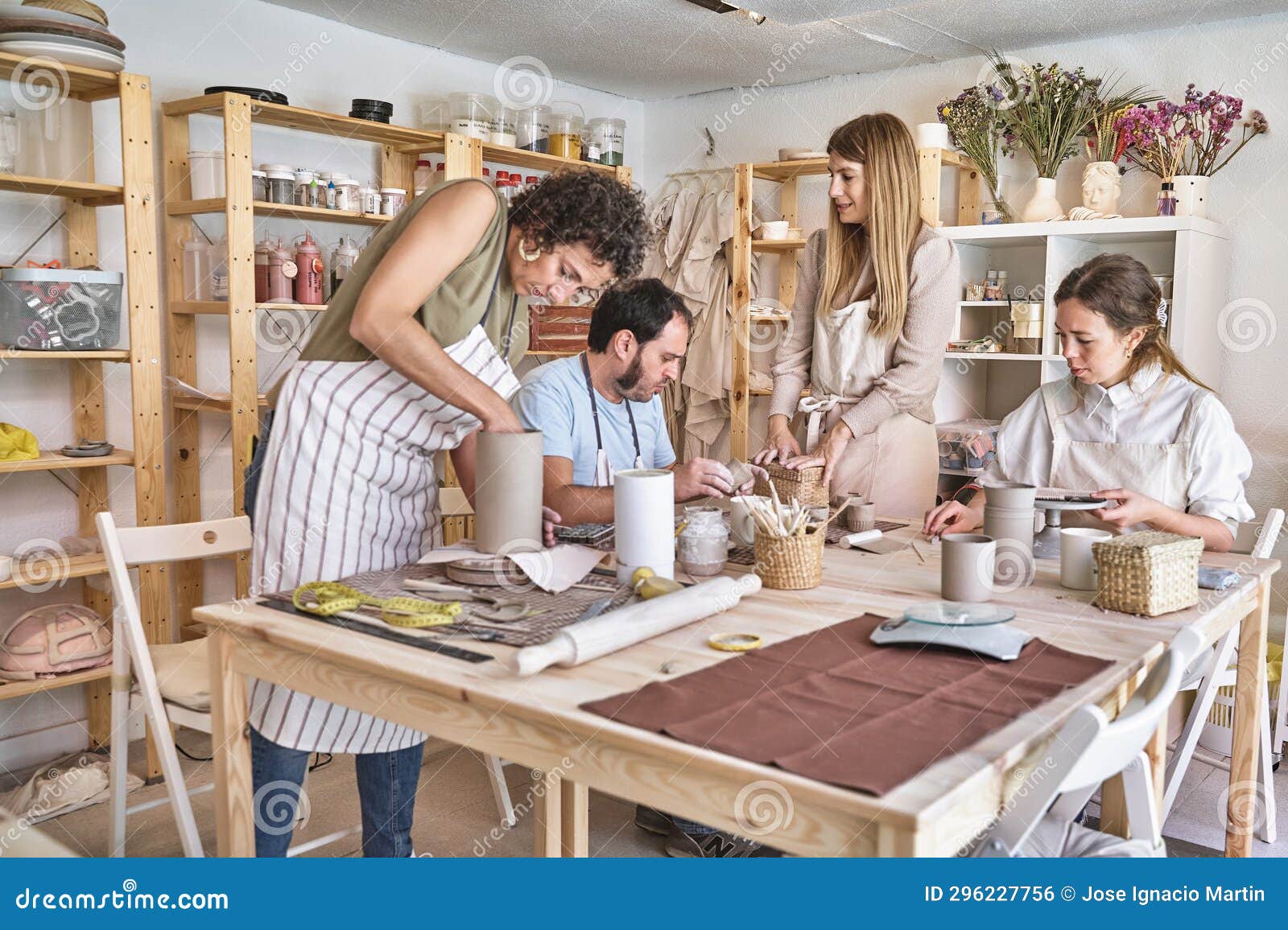 Group of People in Aprons Making Ceramic Crafts Together in a Workshop ...