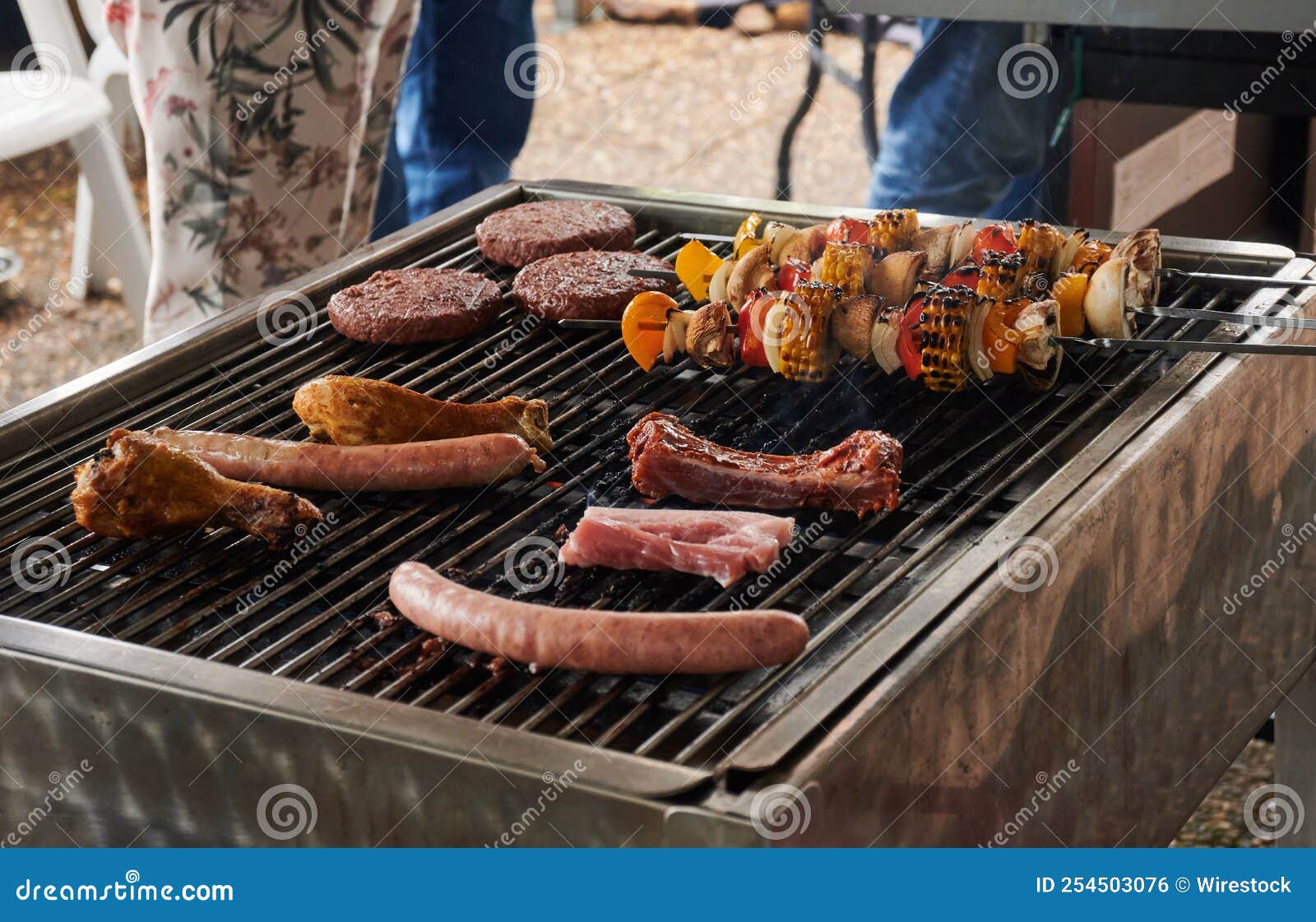 Group of People Around a Barbeque Stand with Food All Over it Stock ...
