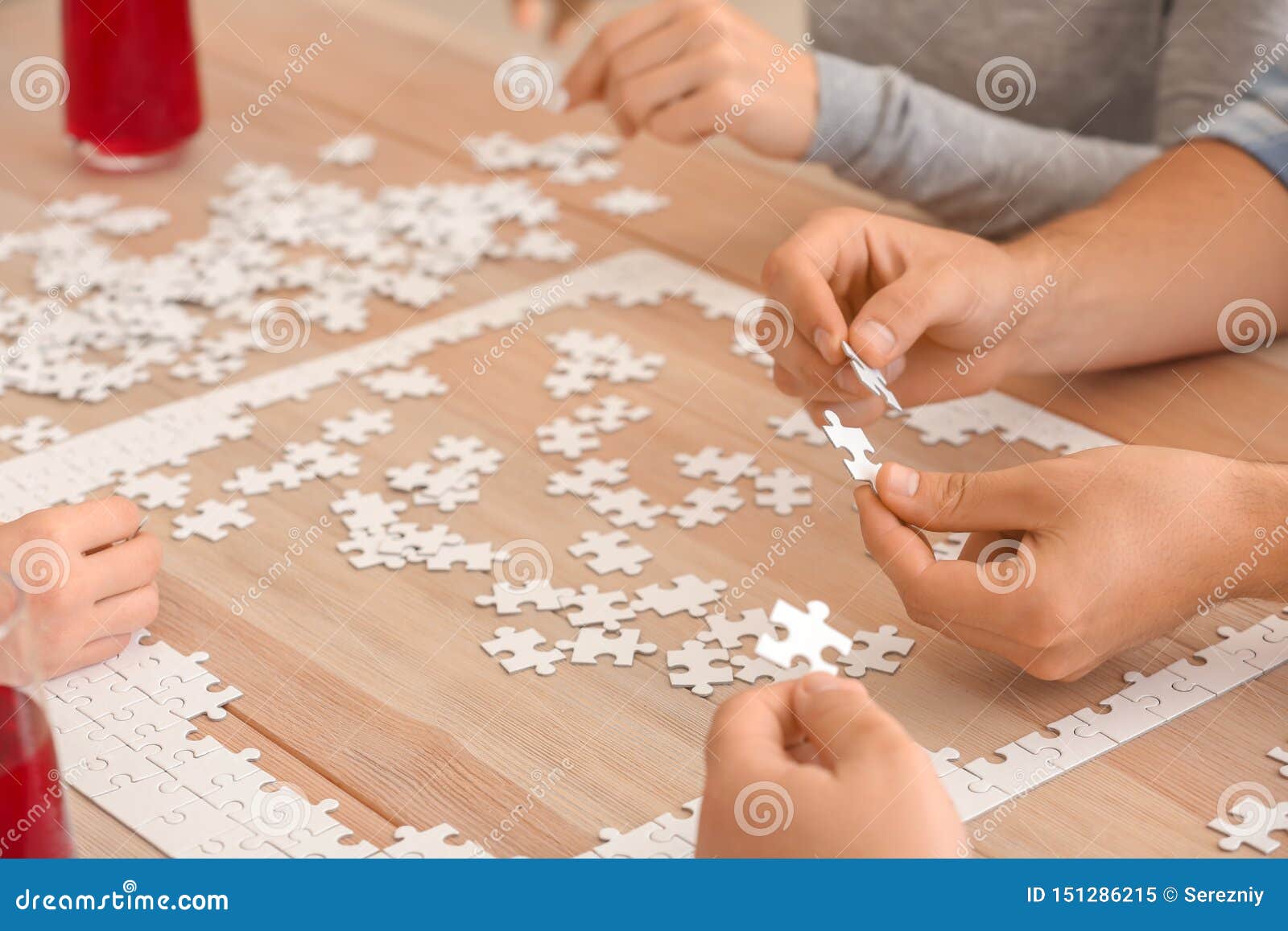 Group of People Assembling Puzzle on Wooden Table Stock Image - Image ...