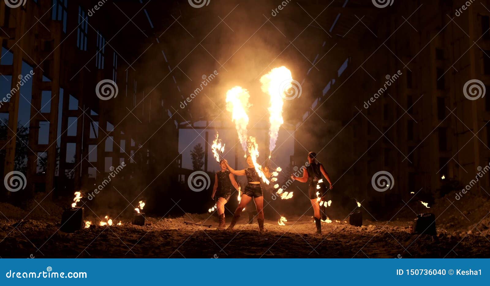 A Group of People with Fire and Torches Dancing at Sunset in the Hangar ...