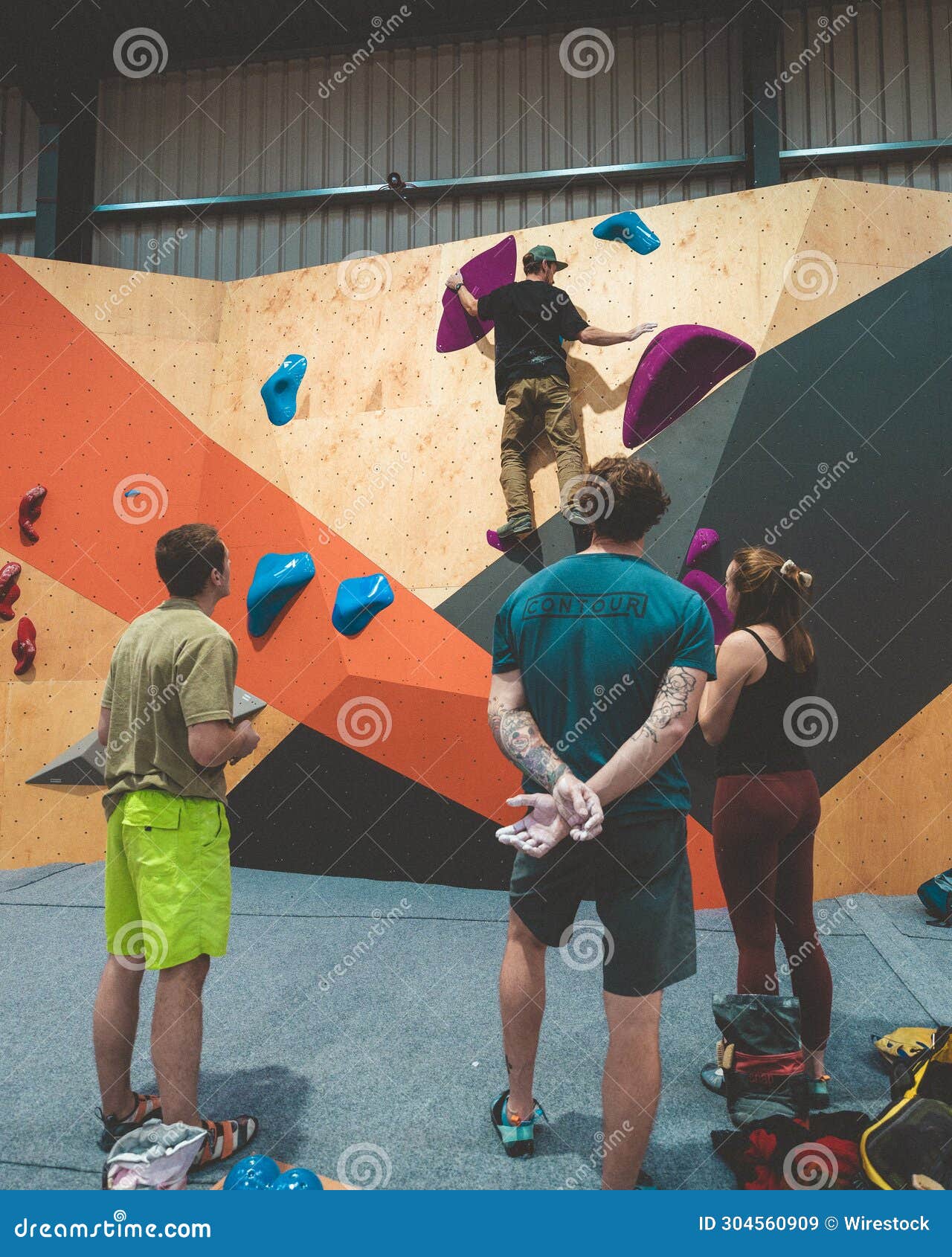 A Group Of People Standing Around Each Other In Front Of A Climbing