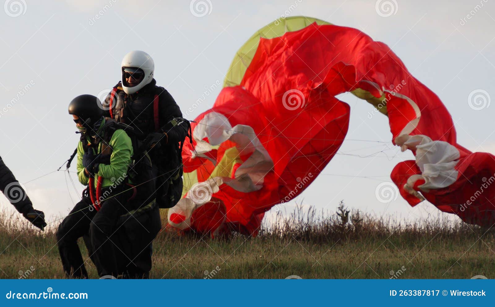Group of People Landing after Paragliding with the Cloudy Sky in the ...