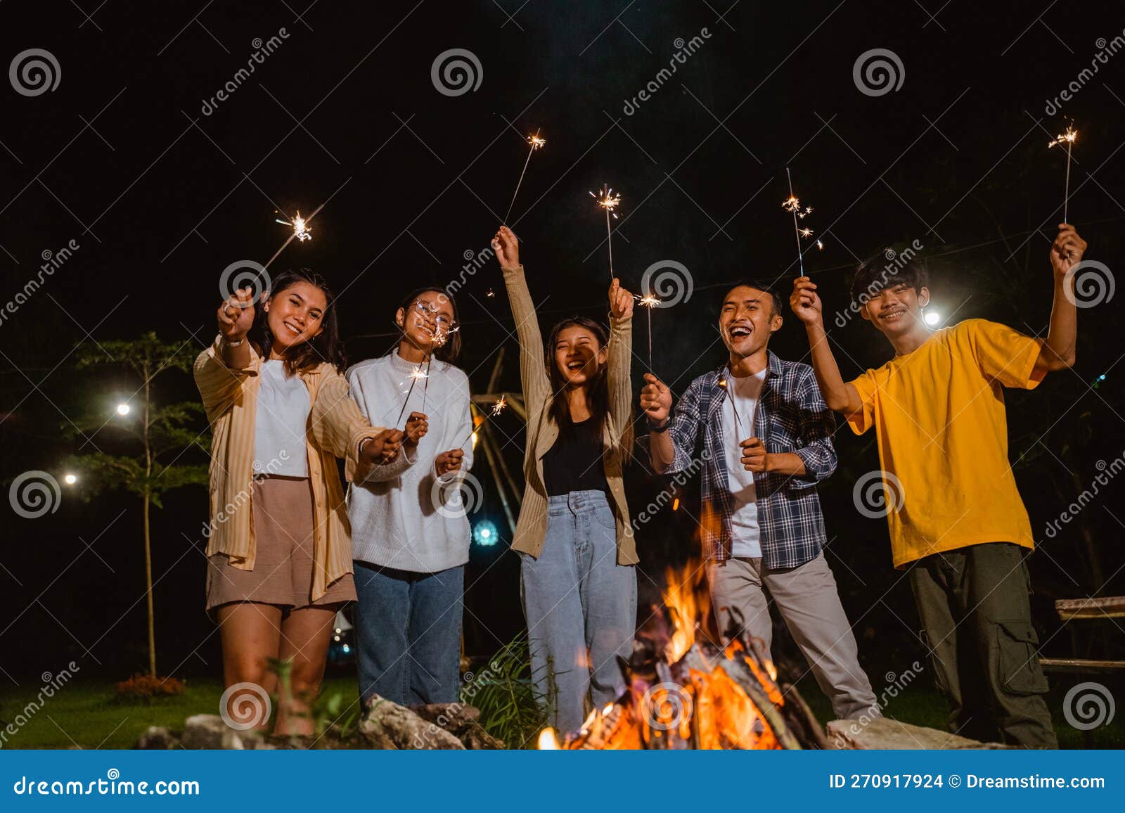 A Group of People Raise Their Fireworks and Smiling Stock Photo - Image ...