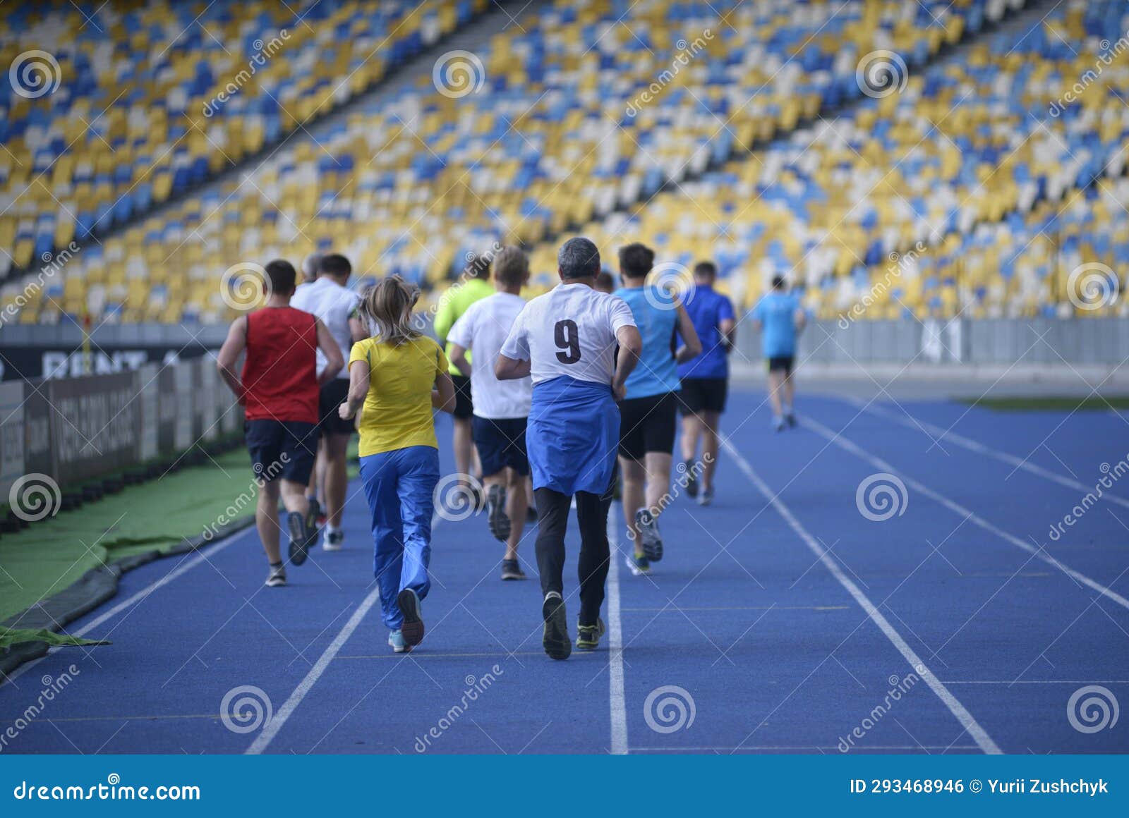 Group of People Running on Tracks of the Stadium in the Evening Light ...