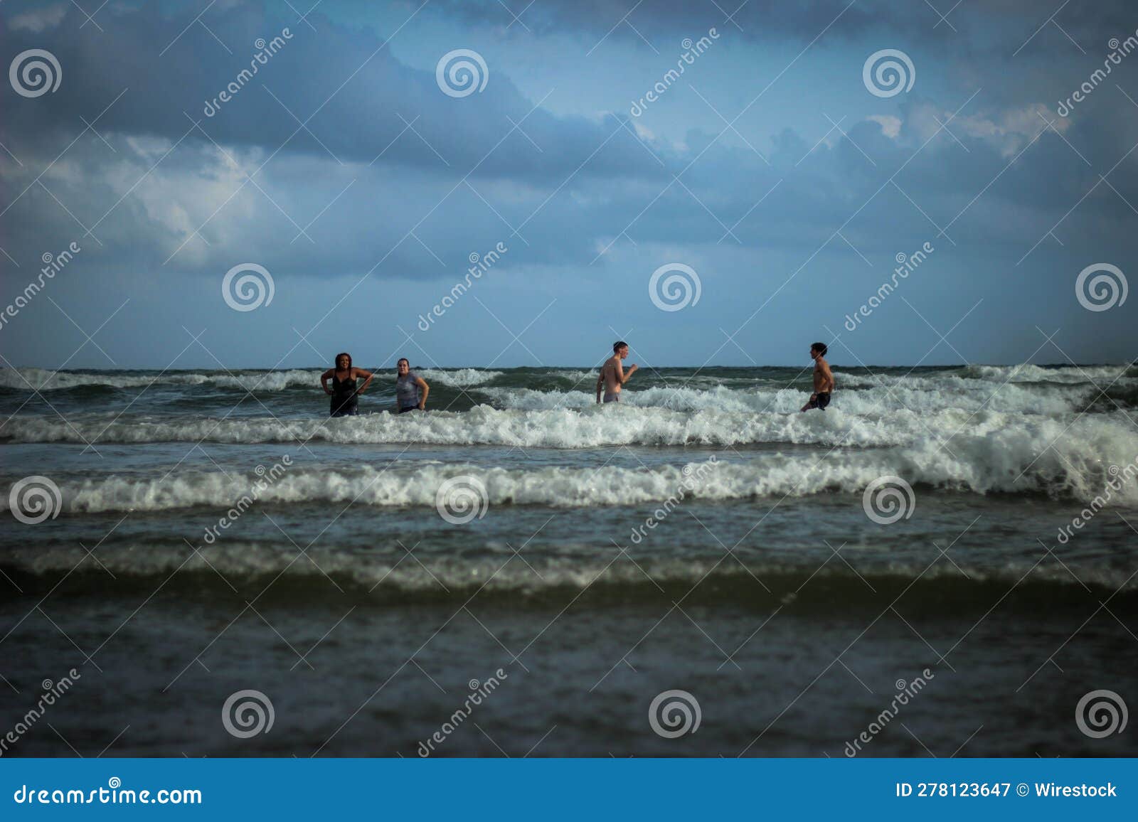 Group of People in the Shallow Waves of the Ocean, the Horizon in the ...
