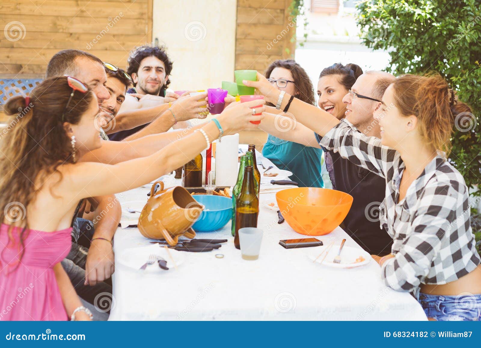 Group of People Sitting Having Lunch Together and Toasting Stock Photo ...