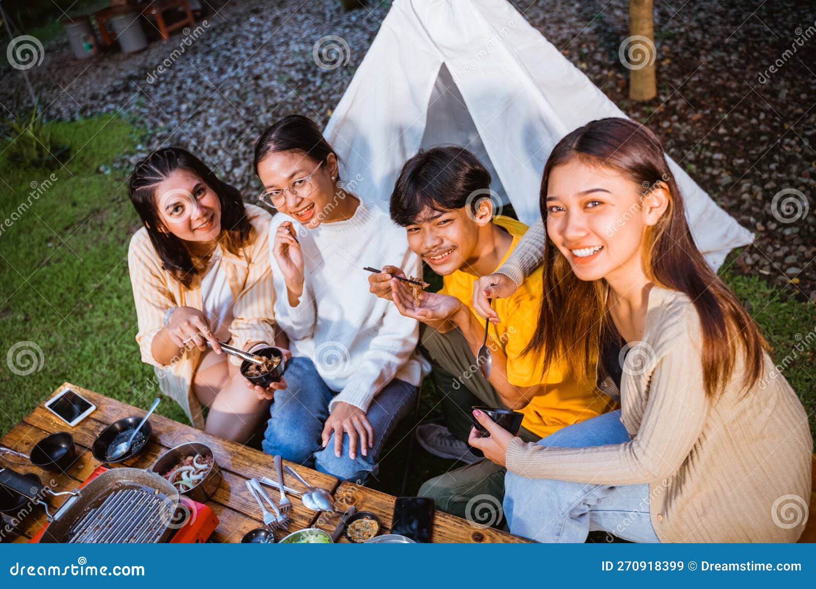 A Group of People Smiling Together while Eating Grilled Beef Stock ...