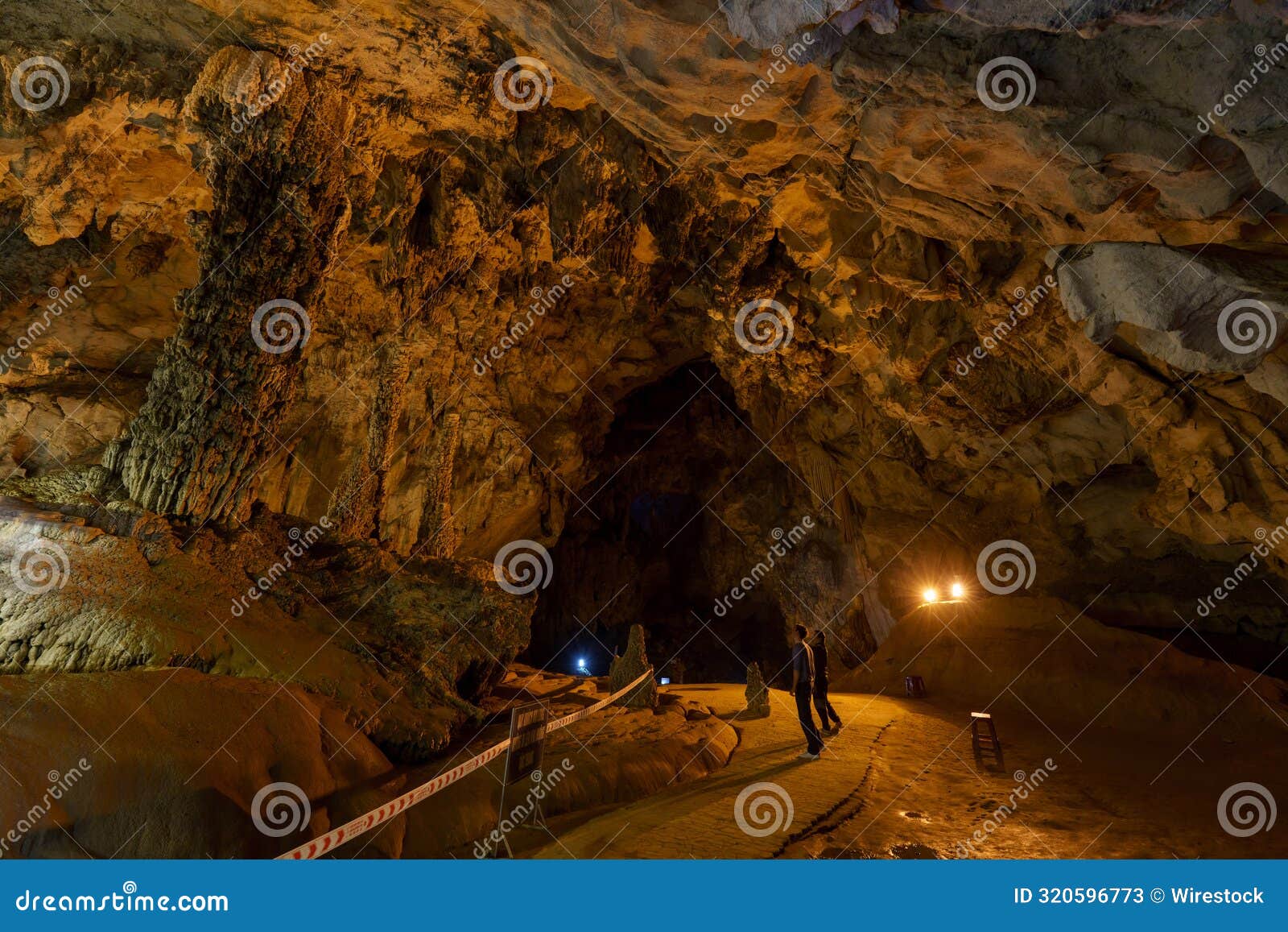Group of People Stand Inside of a Cave at Night, Looking at Rocky ...