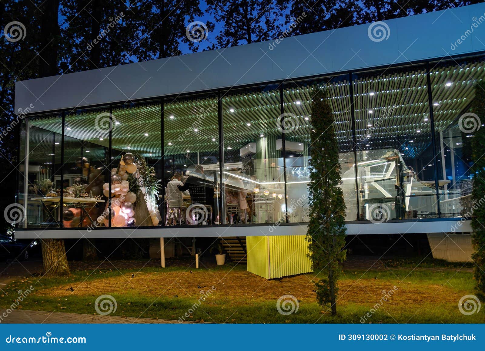 Group of People Standing Outside of Building at Night with Their ...
