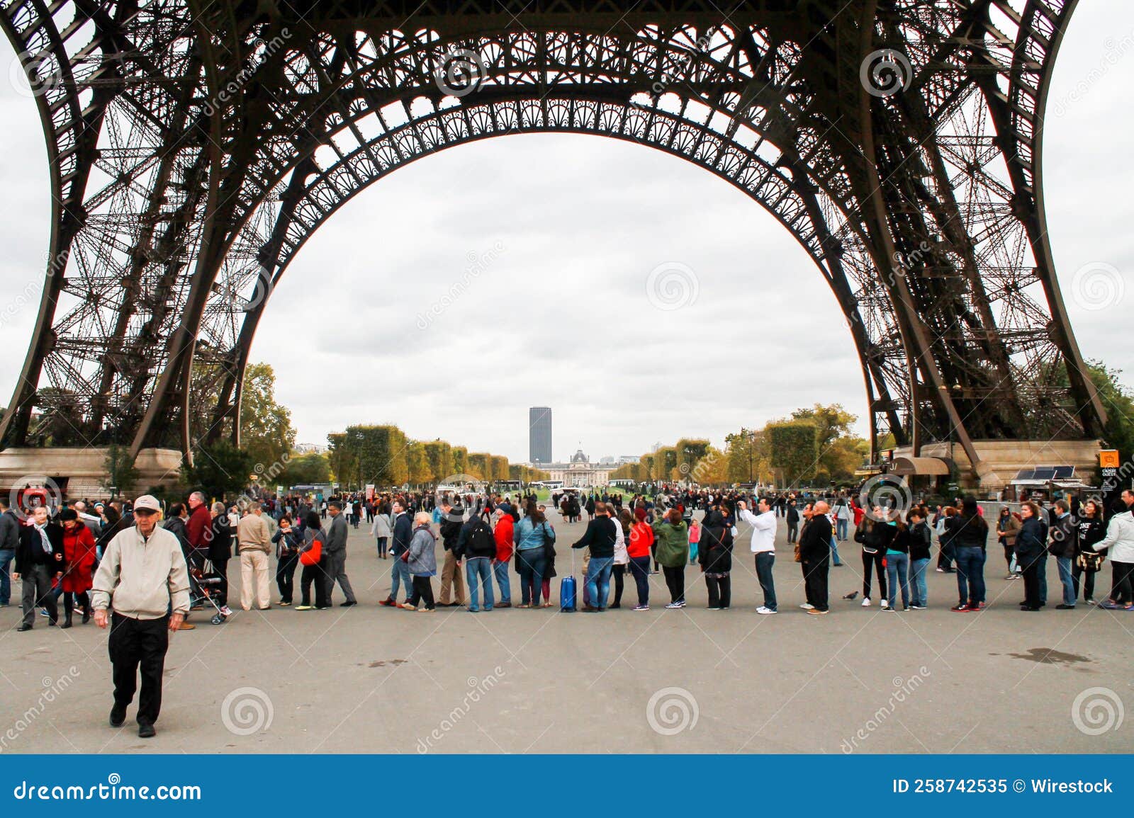 Group of People Under the Eiffel Tower with a Cloudy Sky in the ...