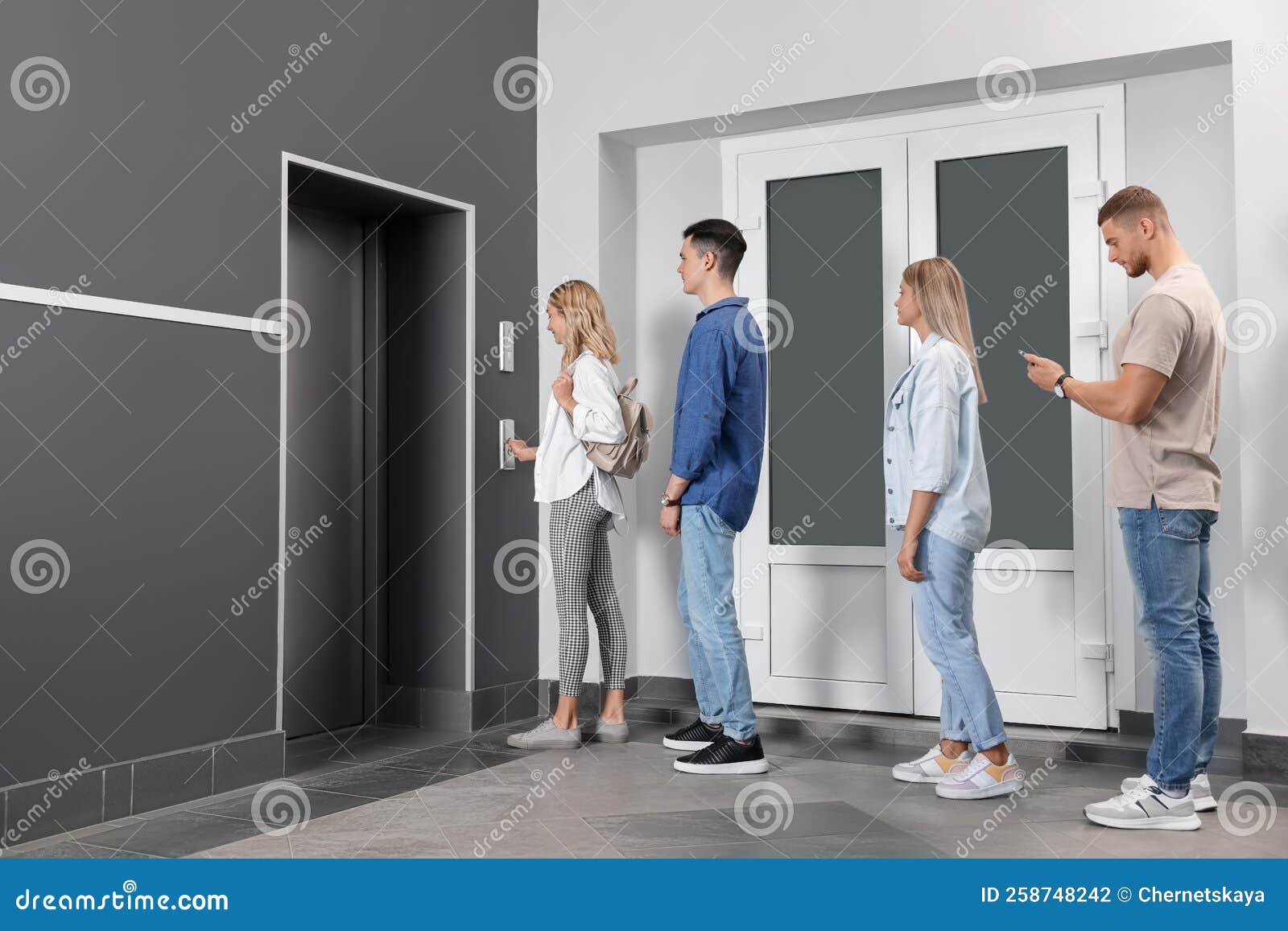 Group of People Waiting in Line for Elevator while Woman Pressing Call ...