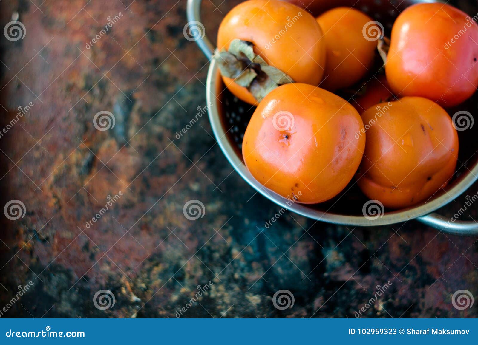 Group of Persimmons in Metal Collander Over Rustic Surface. Stock Image ...