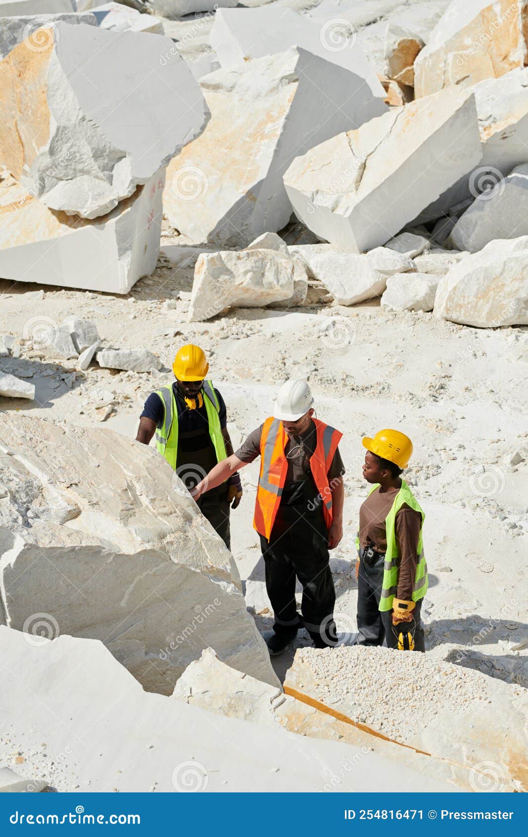 Group of Quality Control Standing in Front of Huge White Marble Rock ...
