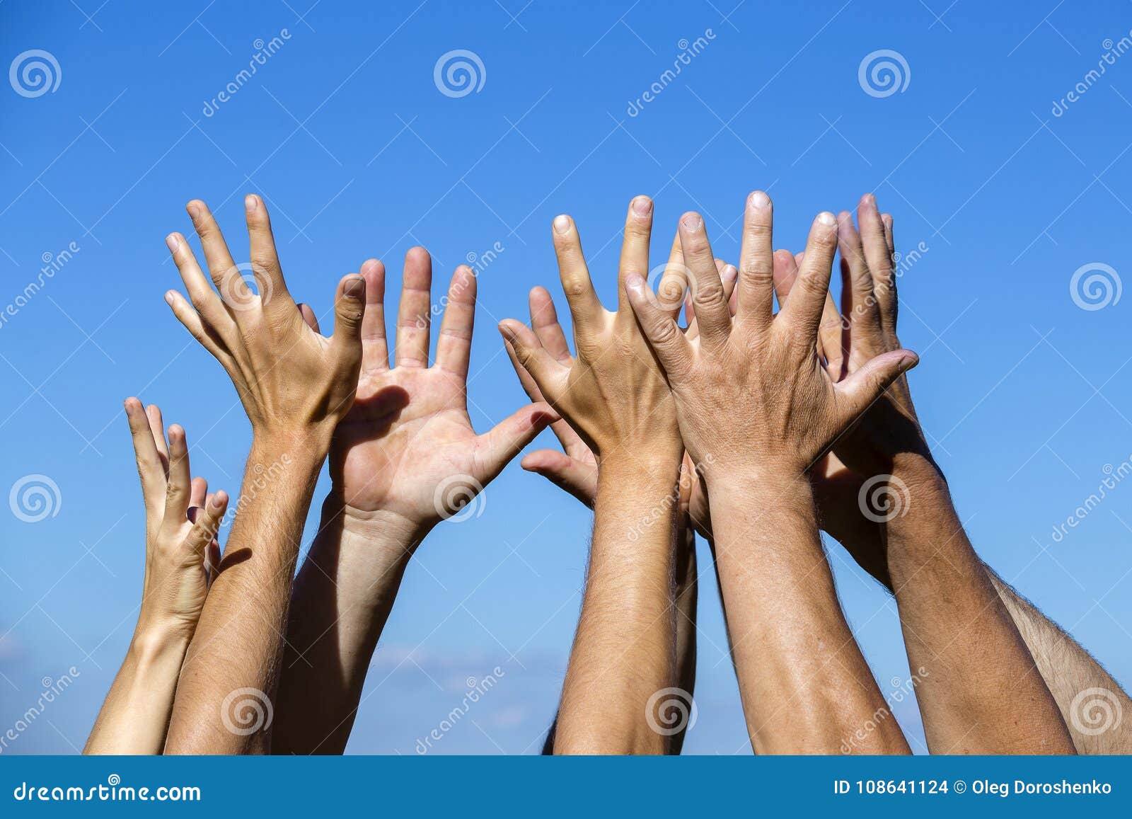 Group Raising Hands Against Blue Sky Background, Close Up Stock Photo ...