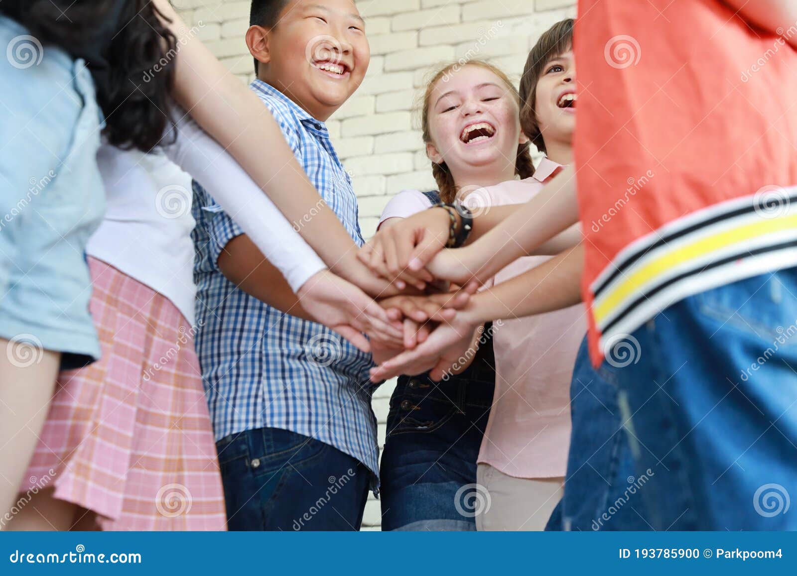Group of School Kids Stacking Hands in Classroom Education Concept ...