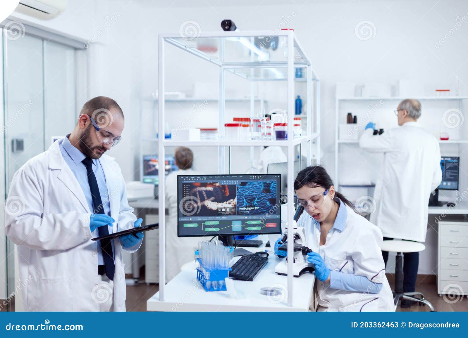 Group of Scientist Doing Health Study Using Microscope and Tablet Pc ...