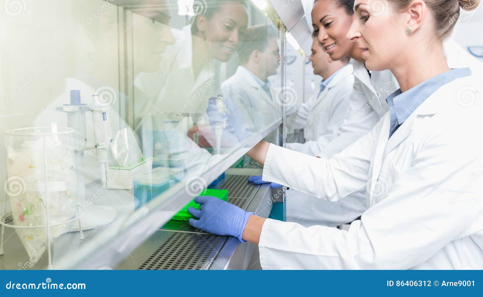 Group of Scientists in Research Laboratory Working Under Splashback ...