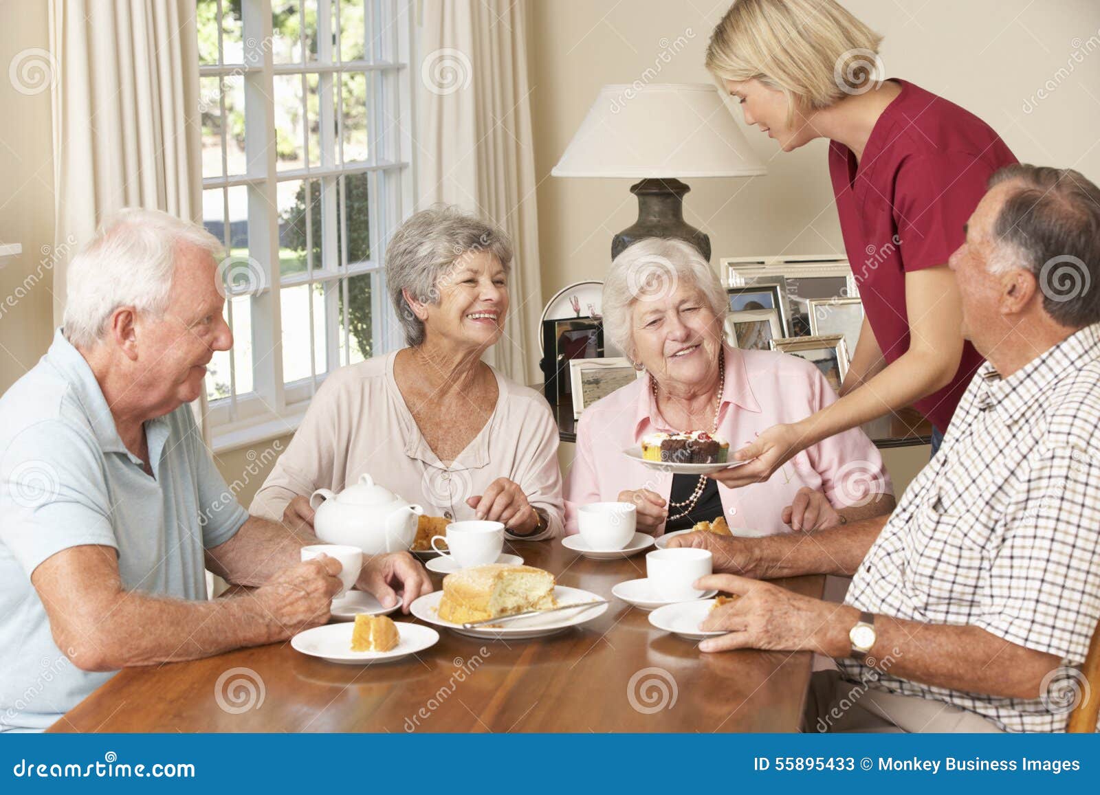 Group of Senior Couples Enjoying Afternoon Tea Together at Home with ...