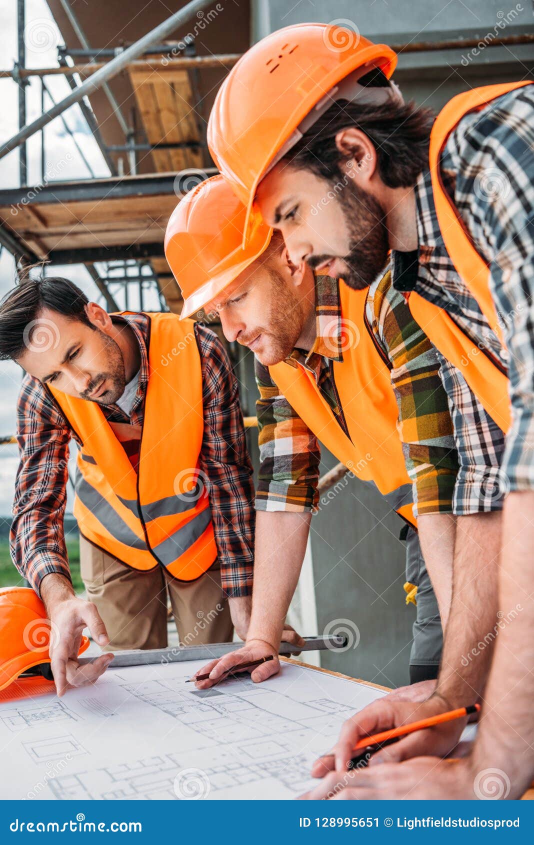 Group of Serious Builders Looking at Building Plan Stock Image - Image ...