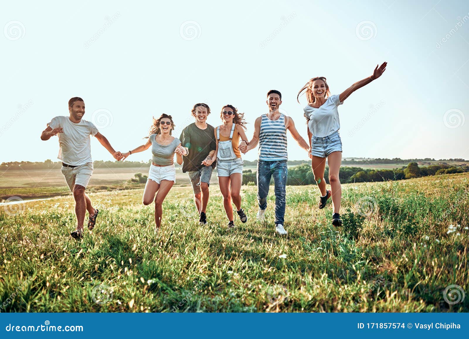 Group of Six Friends Running Down Meadow, Jumping, Cheering and Smiling ...