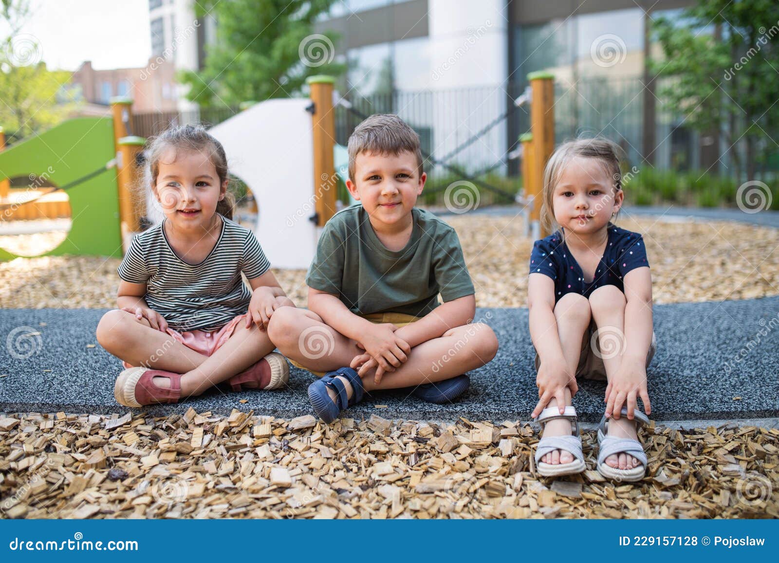 Group of Small Nursery School Children Sitting Outdoors on Playground ...