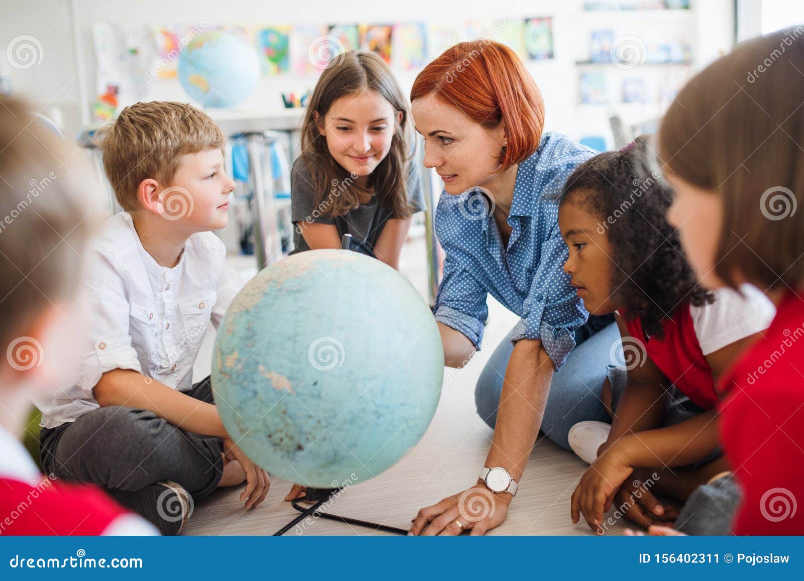 A Group of Small School Kids with Teacher Sitting on the Floor in Class ...