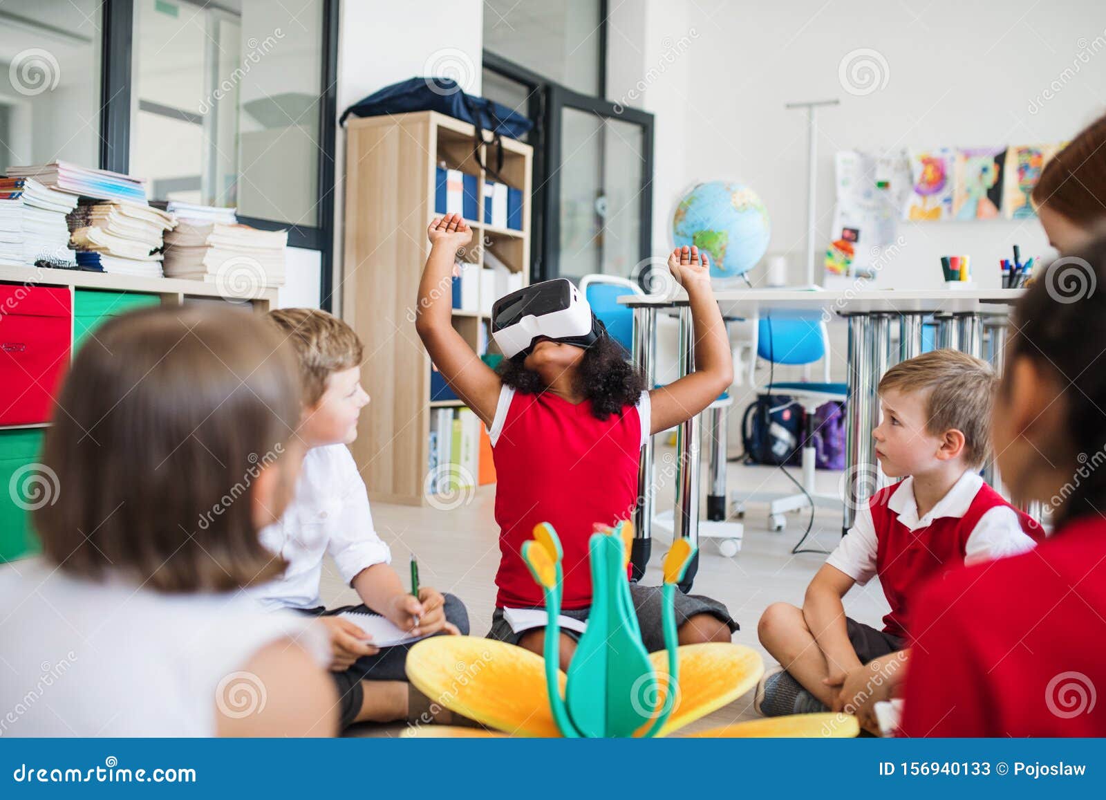A Group of Small School Kids with VR Goggles Sitting on the Floor in ...