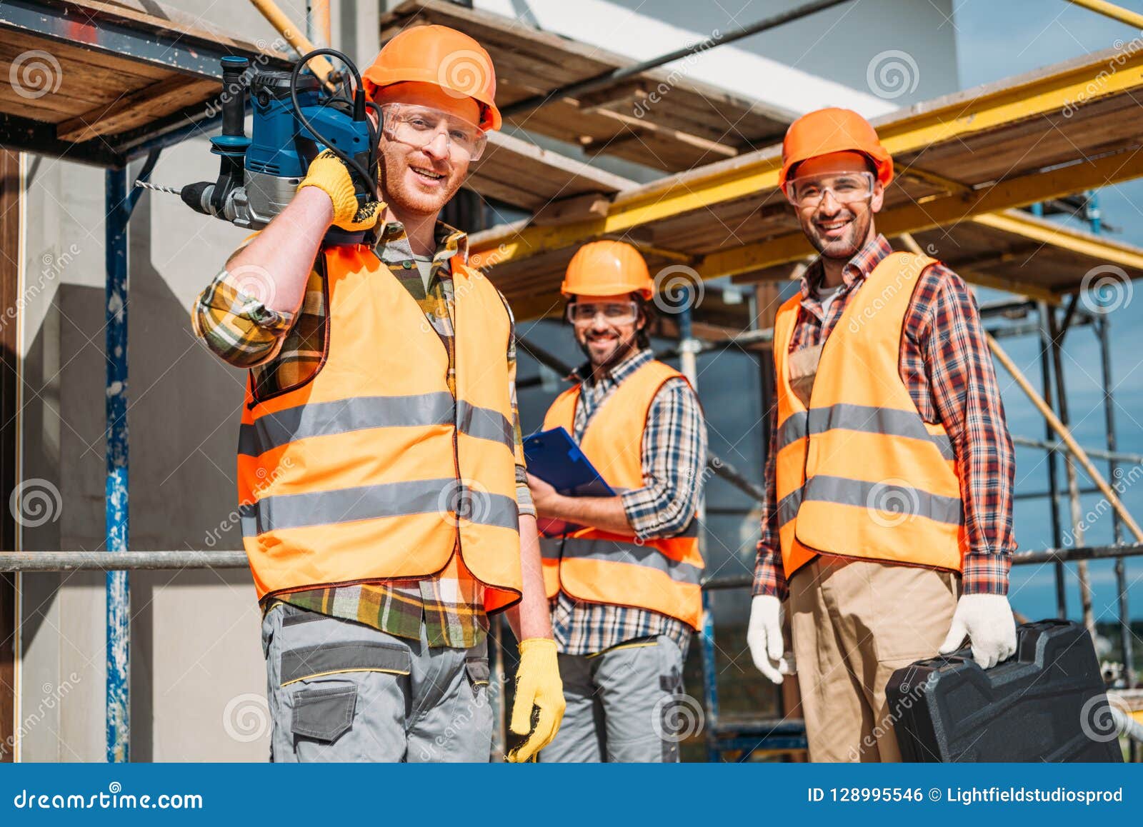 Group of Smiling Builders with Building Equipment Standing at ...