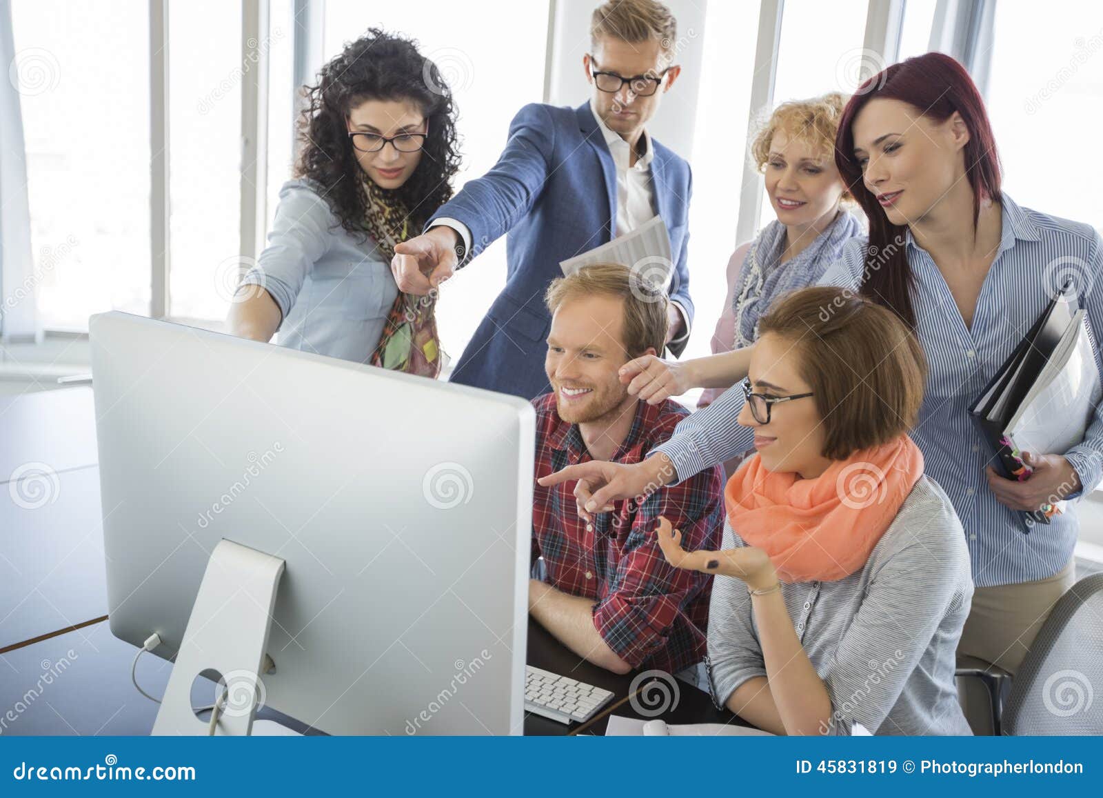 Group of Smiling Businesspeople Using Computer Together in Office Stock ...