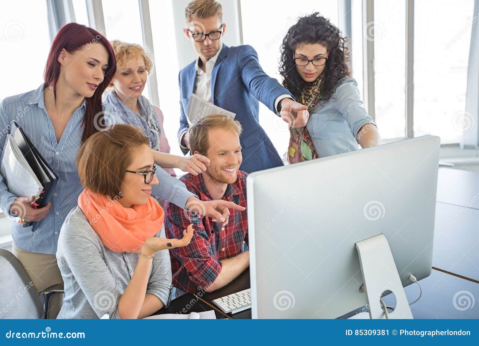 Group of Smiling Businesspeople Using Computer Together in Office Stock ...