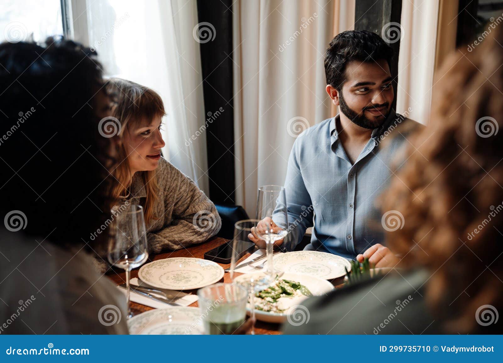 Group of Smiling Friends Talking while Dining in Restaurant Stock Photo ...